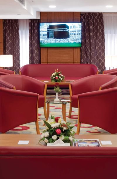 Comfy red lounge chairs in Mina Café at Elaf Bakkah Hotel